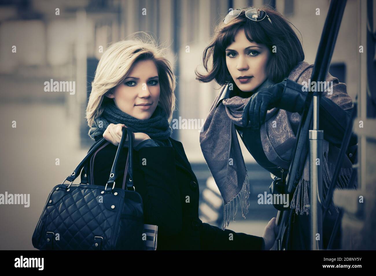 Two happy young fashion women on city street Stylish female model ...