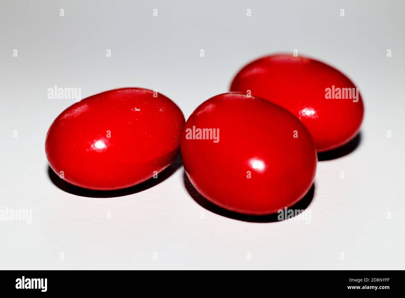 Red shiny candies on a white background - extreme close up Stock Photo ...