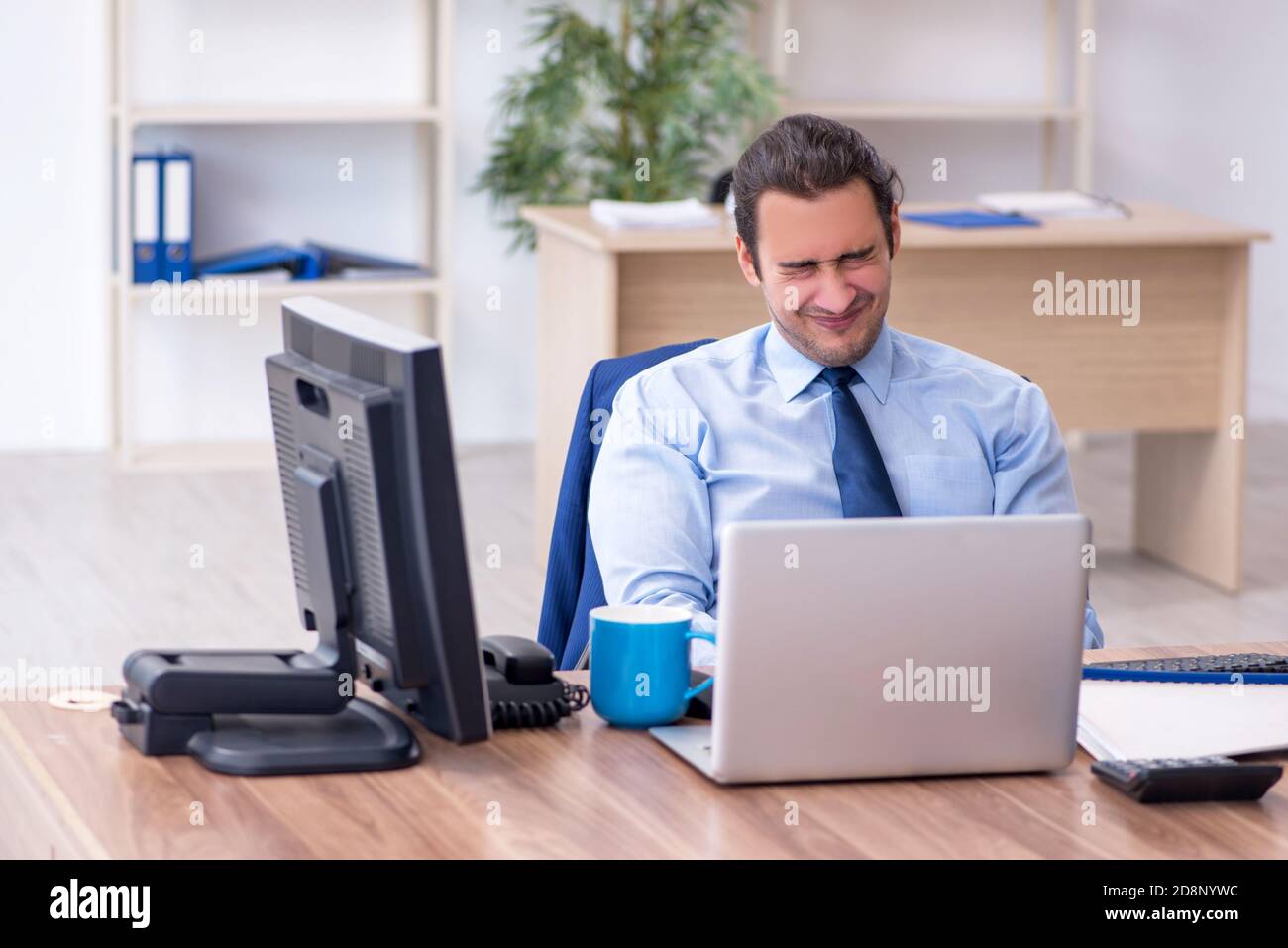 Male employee unhappy with excessive work Stock Photo - Alamy