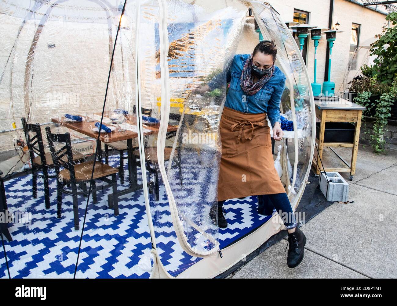 Chicago, USA. 30th Oct, 2020. A waitress steps out of an enclosure at ...