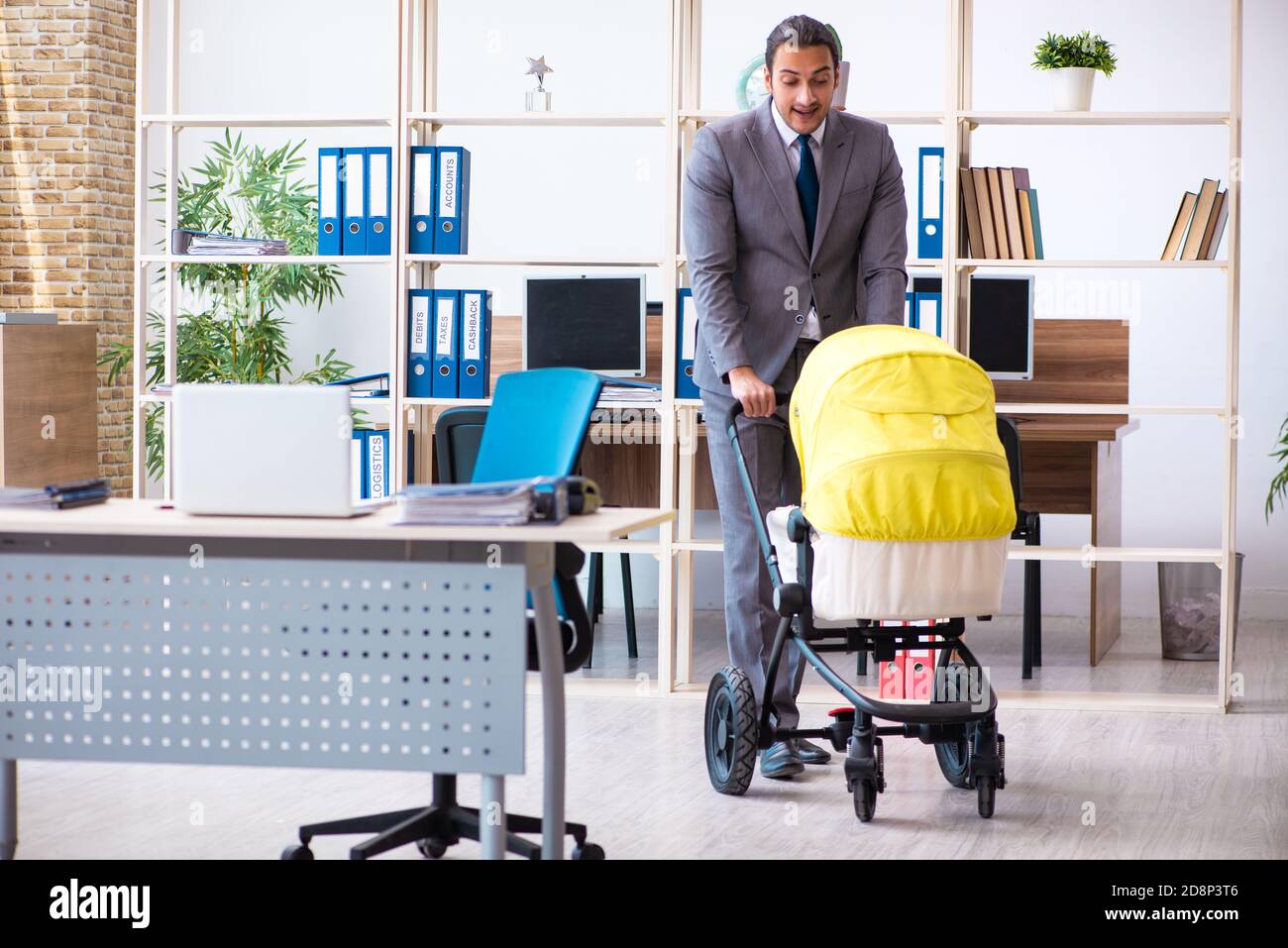 Male employee looking after newborn at workplace Stock Photo - Alamy