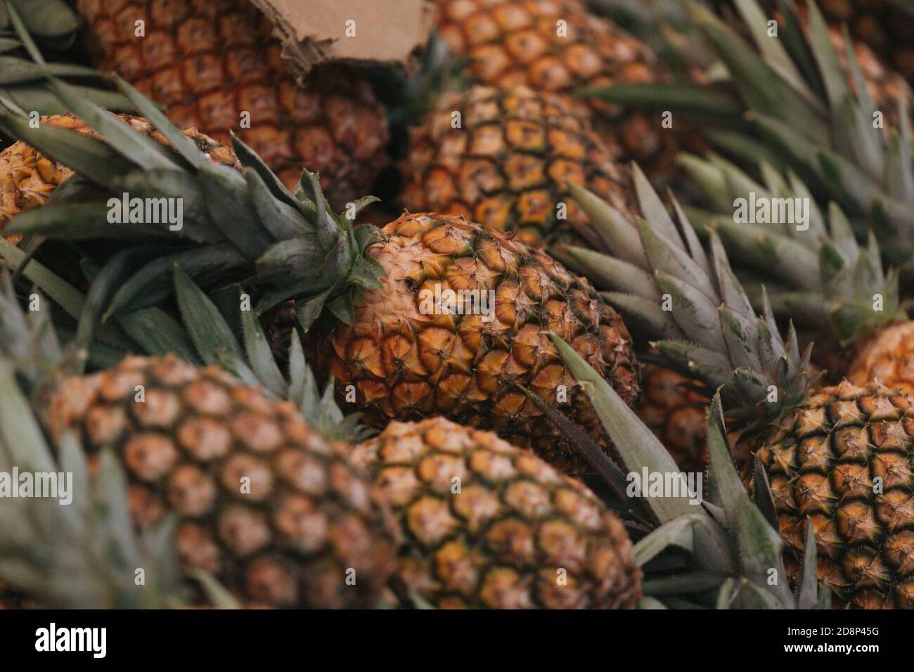 Selective focus shot of pineapples on a shelf for sale at a market ...