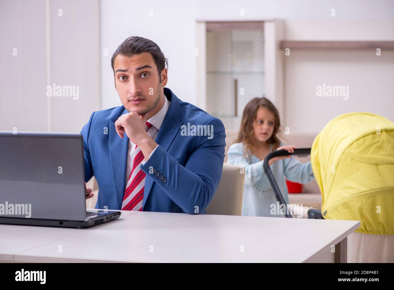 Young father of two children working from house Stock Photo - Alamy