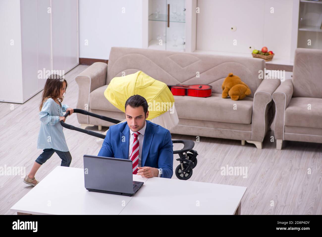 Young father of two children working from house Stock Photo - Alamy
