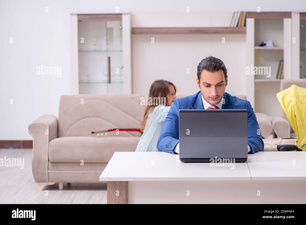 Young father of two children working from house Stock Photo - Alamy
