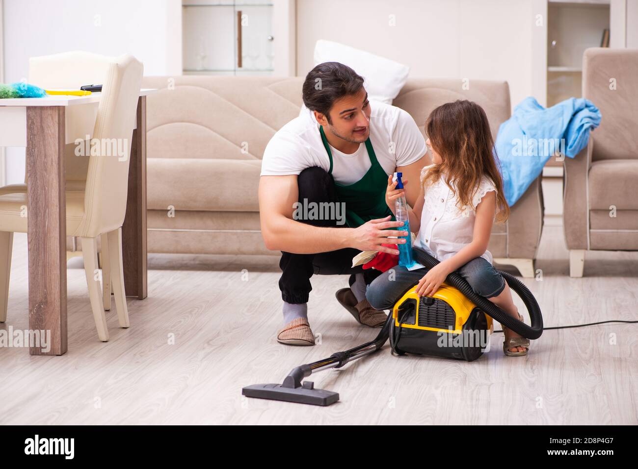 Young contractor cleaning the house with his small daughter Stock Photo ...