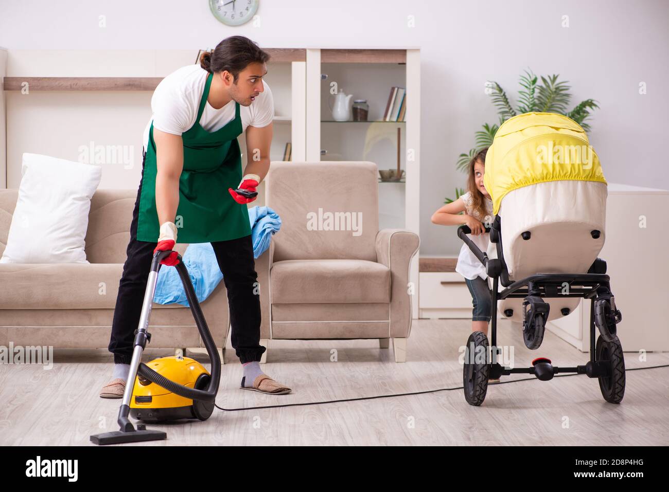 Young contractor cleaning the house with his small daughter Stock Photo ...
