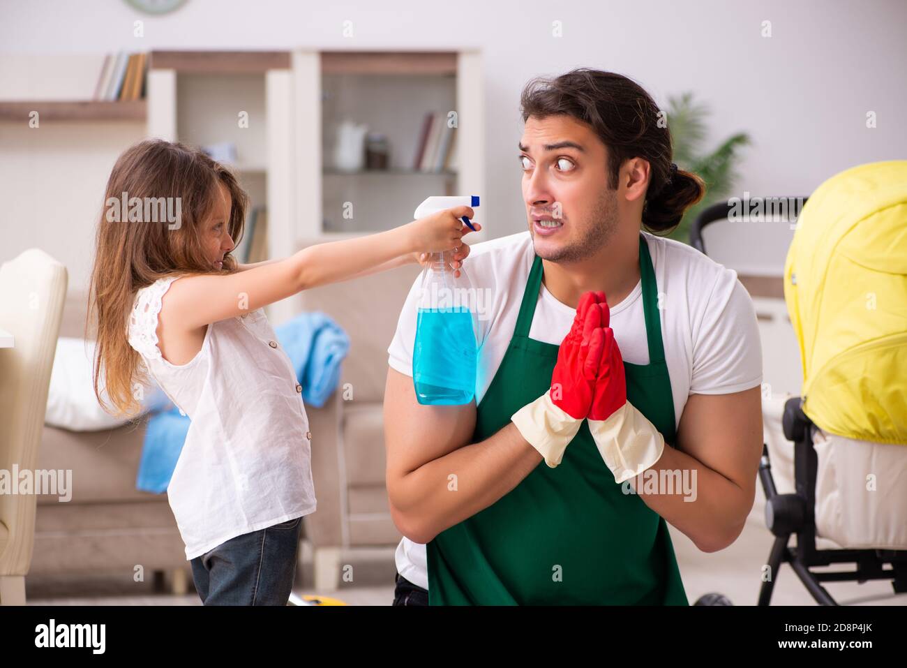 Young contractor cleaning the house with his small daughter Stock Photo ...