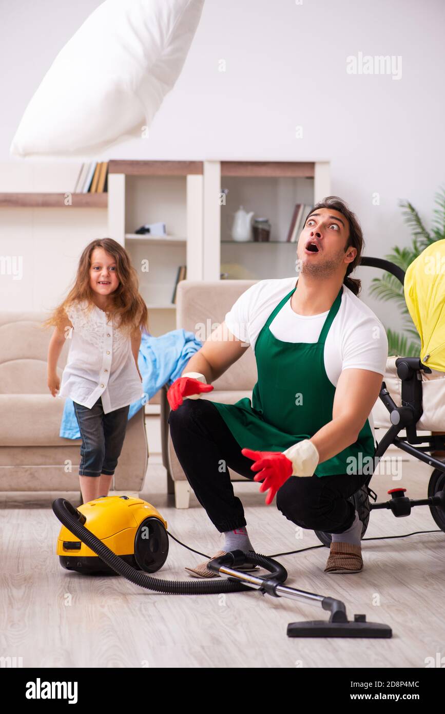 Young contractor cleaning the house with his small daughter Stock Photo ...