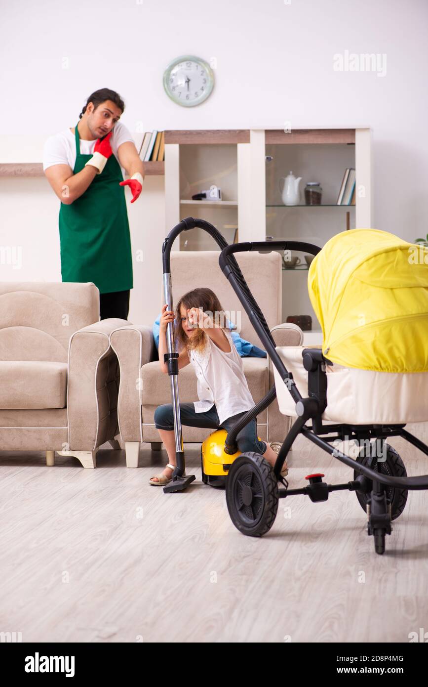 Young contractor cleaning the house with his small daughter Stock Photo ...