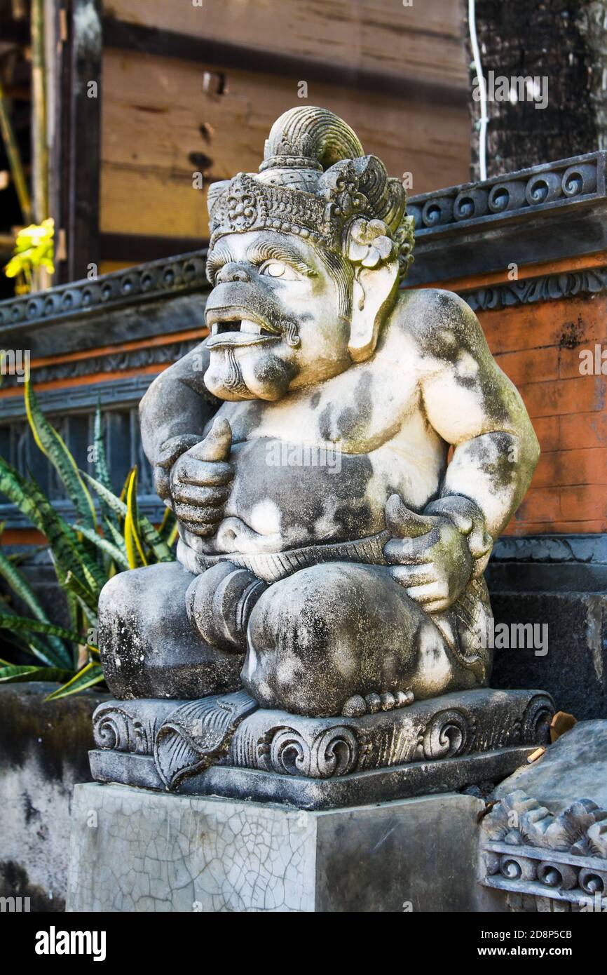 Traditional stone statue depicting demon sitting on front of temple. He ...