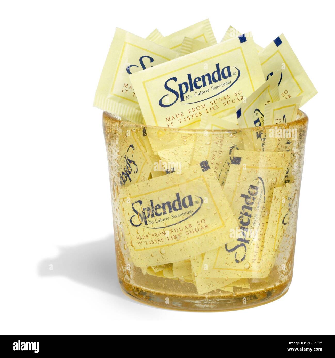 A yellow glass container full of Splenda packets photographed on a ...