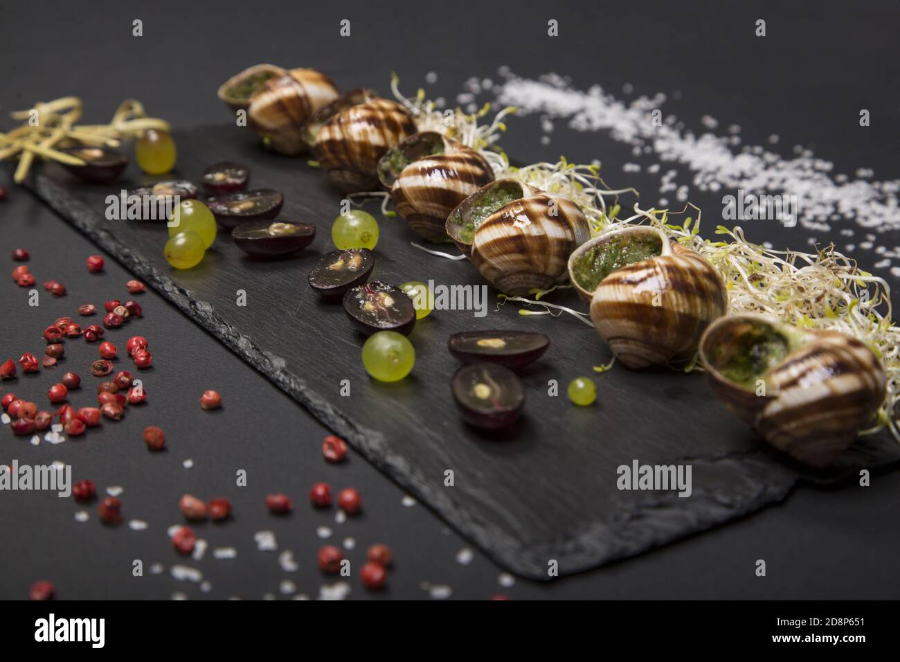 Closeup shot of Burgundy snails on black plate Stock Photo - Alamy