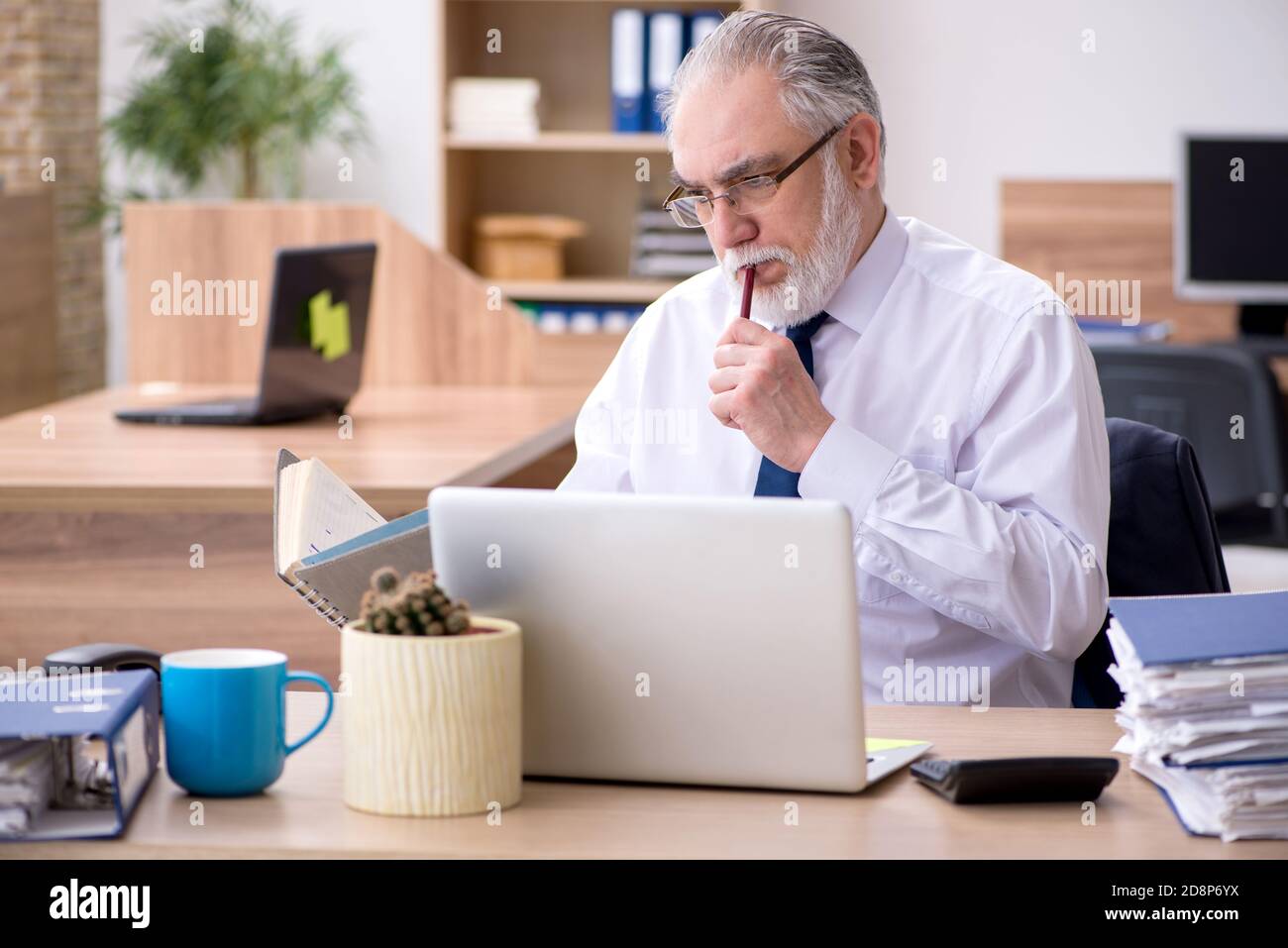 Old employee working in the office Stock Photo - Alamy