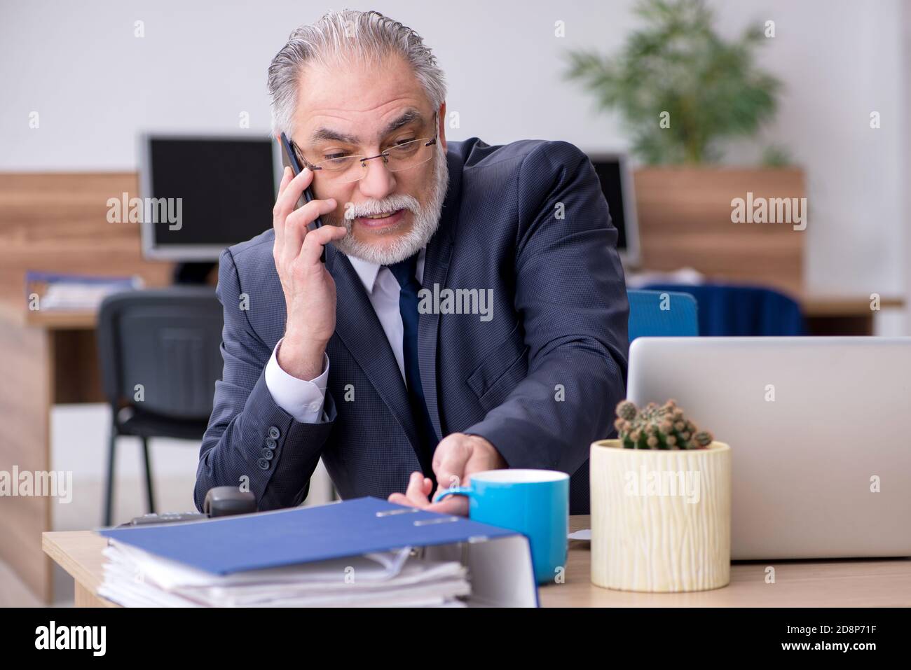 Old employee working in the office Stock Photo - Alamy