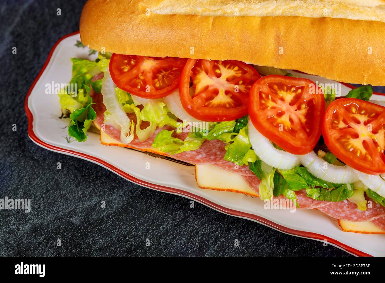 Sub made from french bread, muenster cheese, salami and vegetable. Take ...