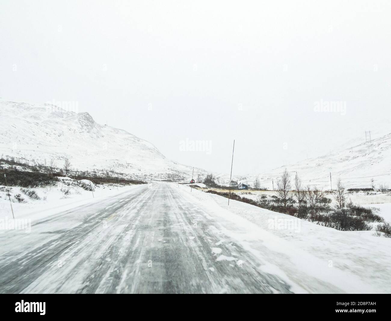 Driving through blizzard snowstorm on black ice and snowy white road ...