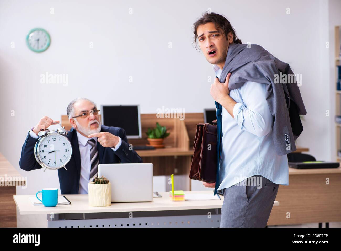 Old boss and young male employee in time management concept Stock Photo ...
