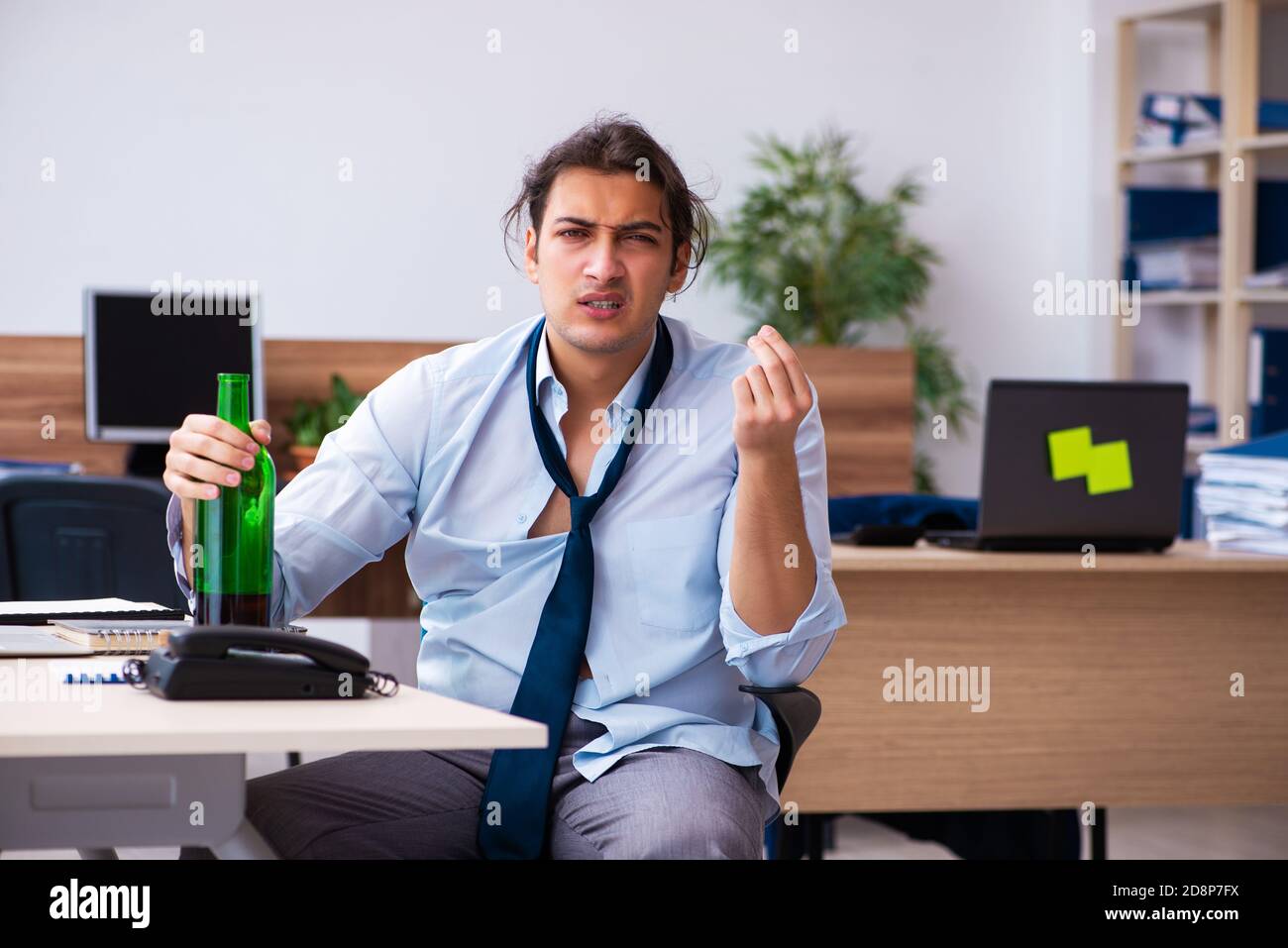 Male employee drinking alcohol at workplace Stock Photo - Alamy