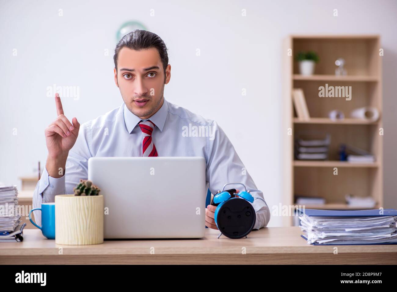 Male employee in time management concept Stock Photo - Alamy