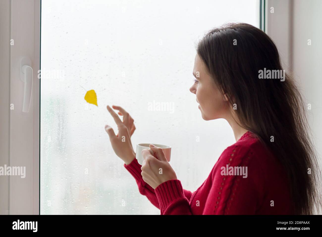 Woman looking through window rain hi-res stock photography and images ...