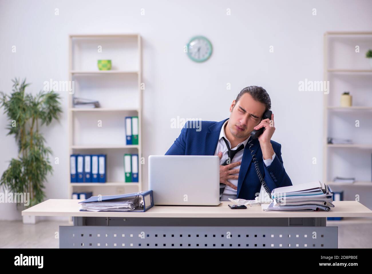 Male employee suffering at workplace Stock Photo - Alamy