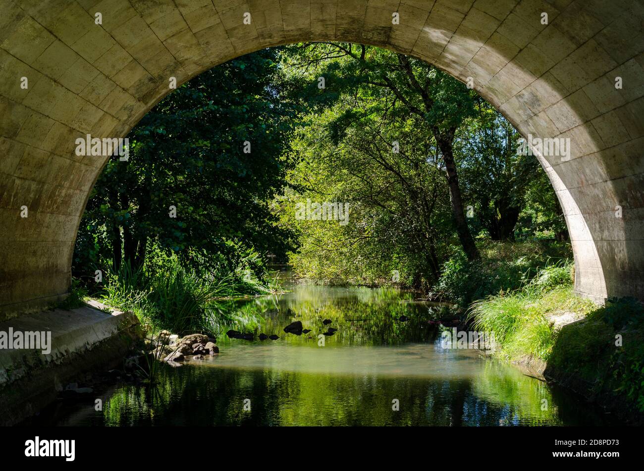 small river flowing underneath a bridge in france Stock Photo - Alamy