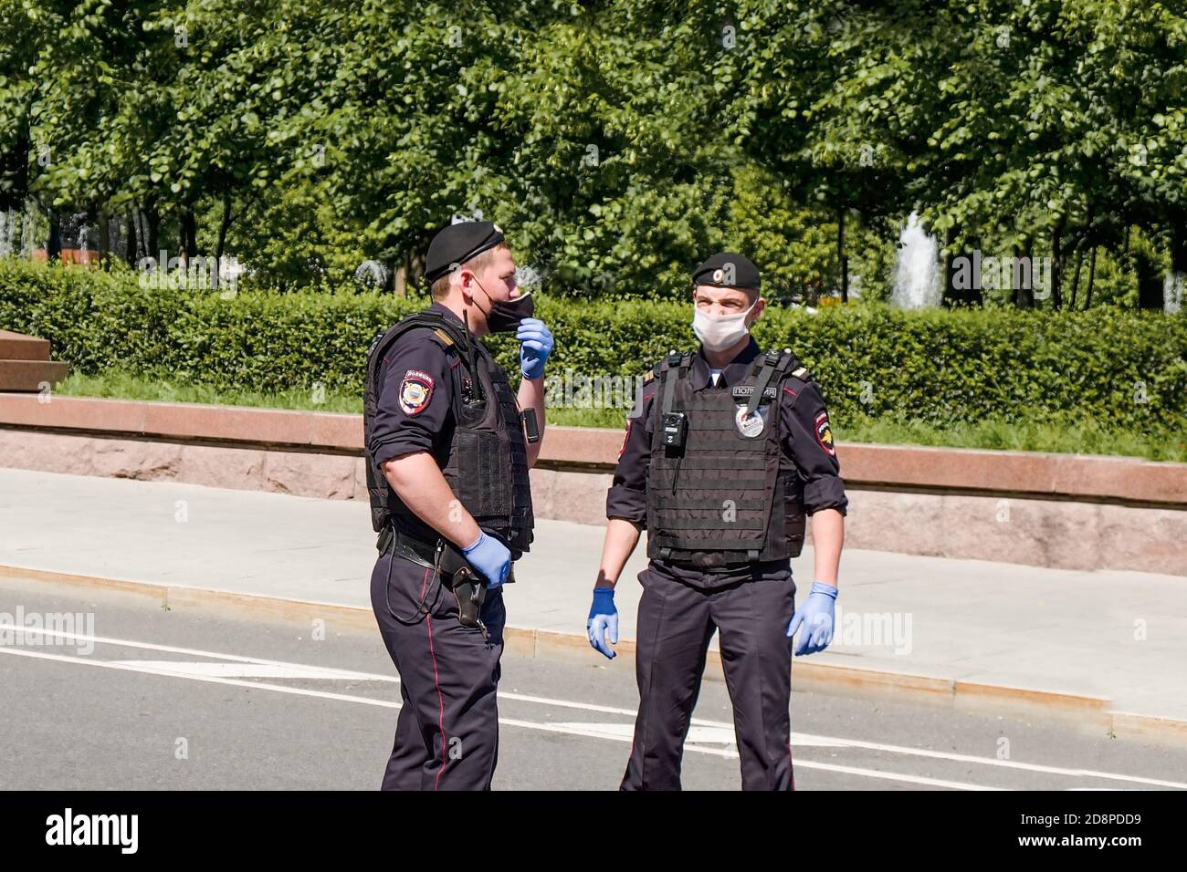 Two armed bodyguards in black uniforms, protective masks, gloves patrol ...