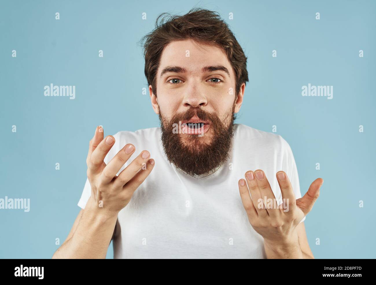Puzzled man with a beard on a blue background emotions of surprise ...