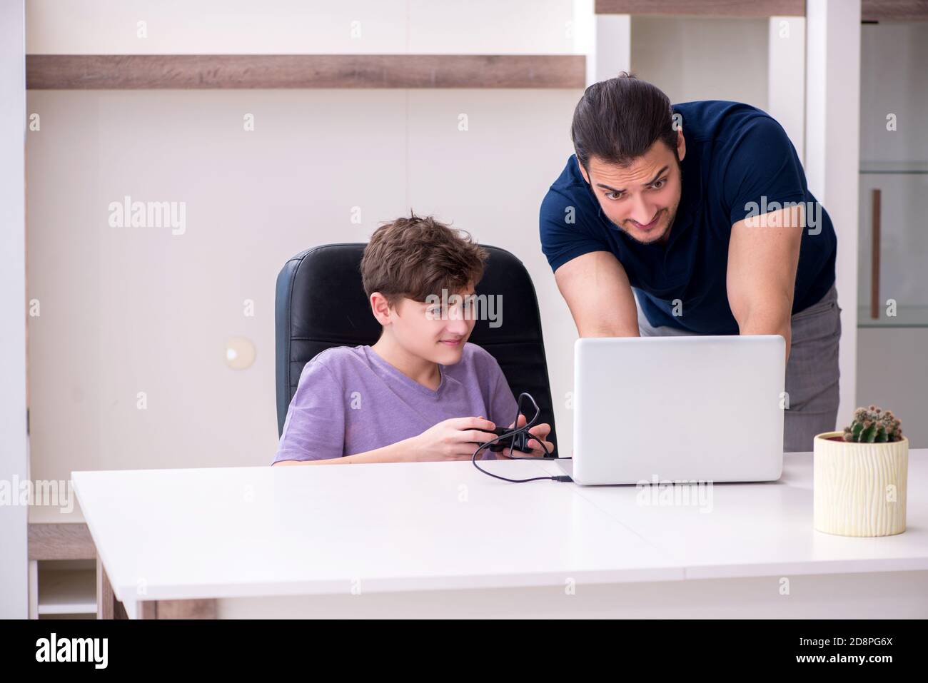 Father and schoolboy playing computer games at home Stock Photo - Alamy