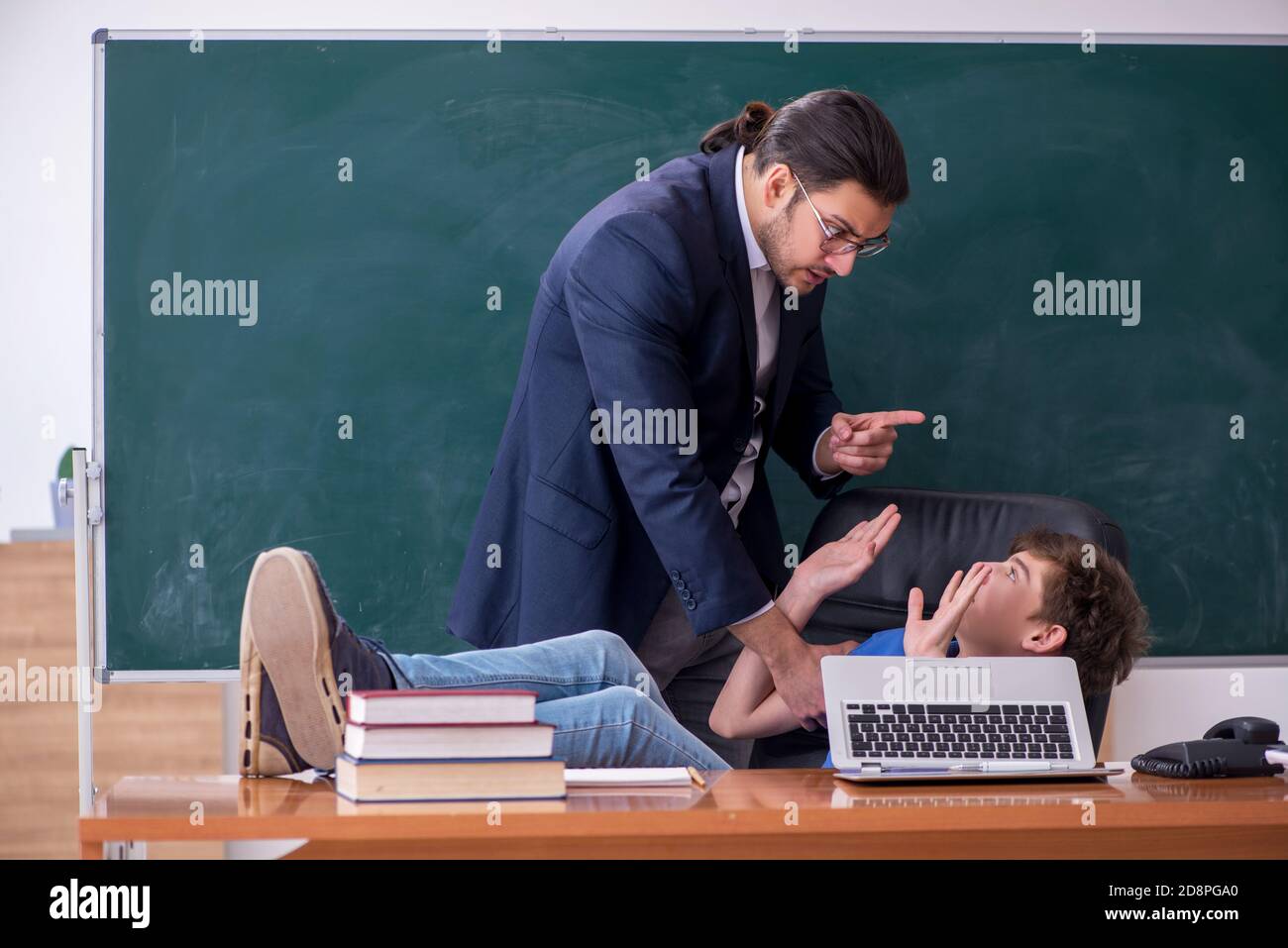Male teacher and schoolboy in the classroom Stock Photo - Alamy