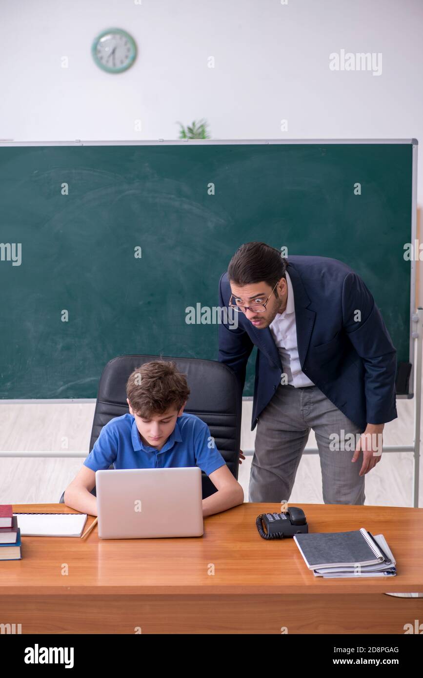 Male teacher and schoolboy in the classroom Stock Photo - Alamy