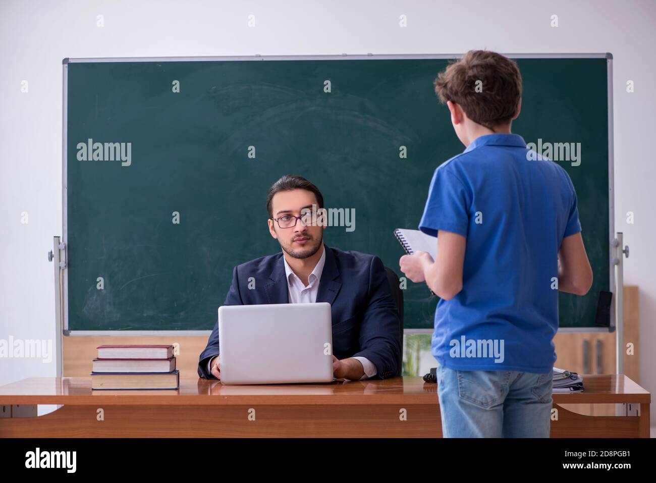 Male teacher and schoolboy in the classroom Stock Photo - Alamy