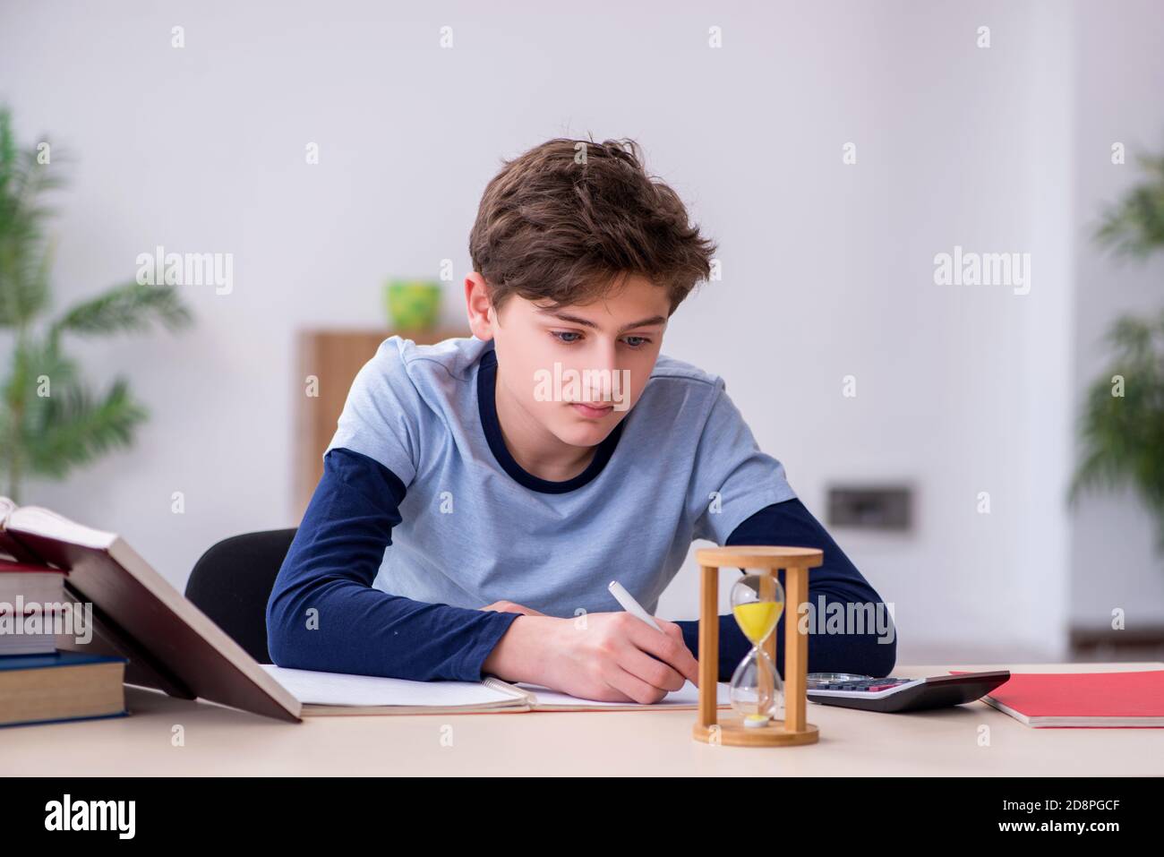 Boy preparing for exams in time management concept Stock Photo - Alamy