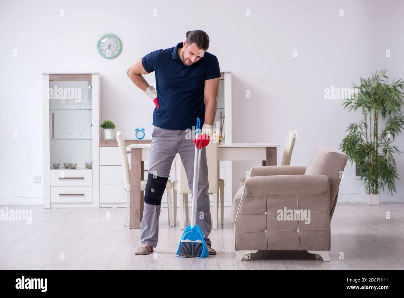 Young leg injured contractor cleaning house Stock Photo - Alamy