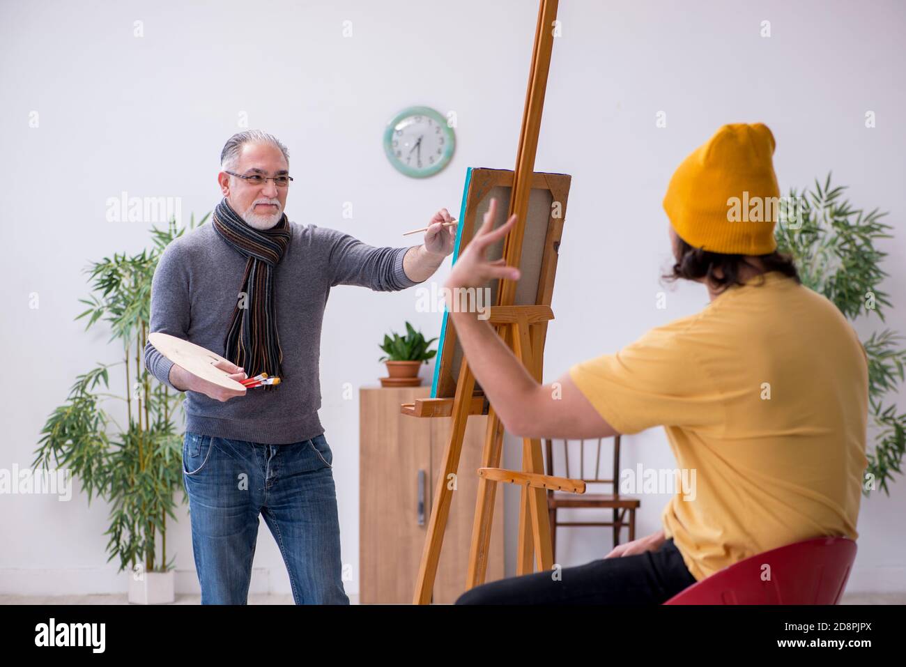 Old portraitist and younger male model Stock Photo - Alamy