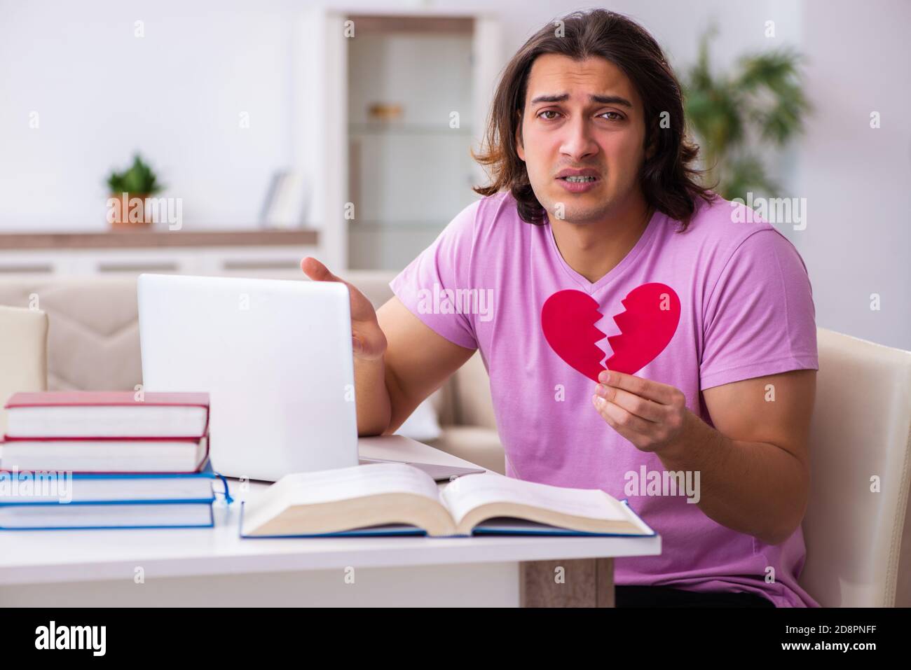 Young student in one-sided love concept at home Stock Photo - Alamy