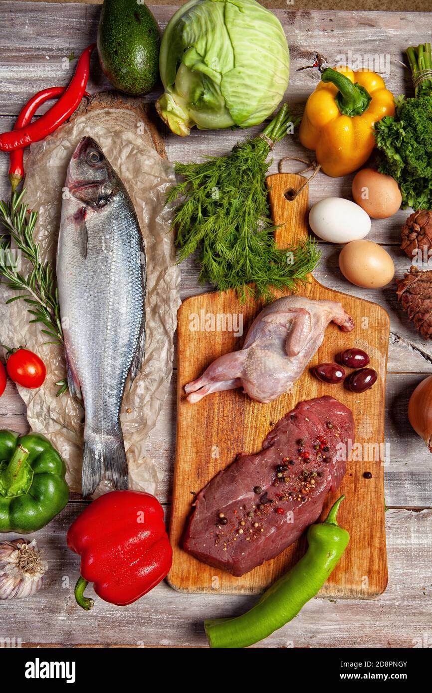 Chicken, fish and vegetables on an old wooden desk Stock Photo - Alamy