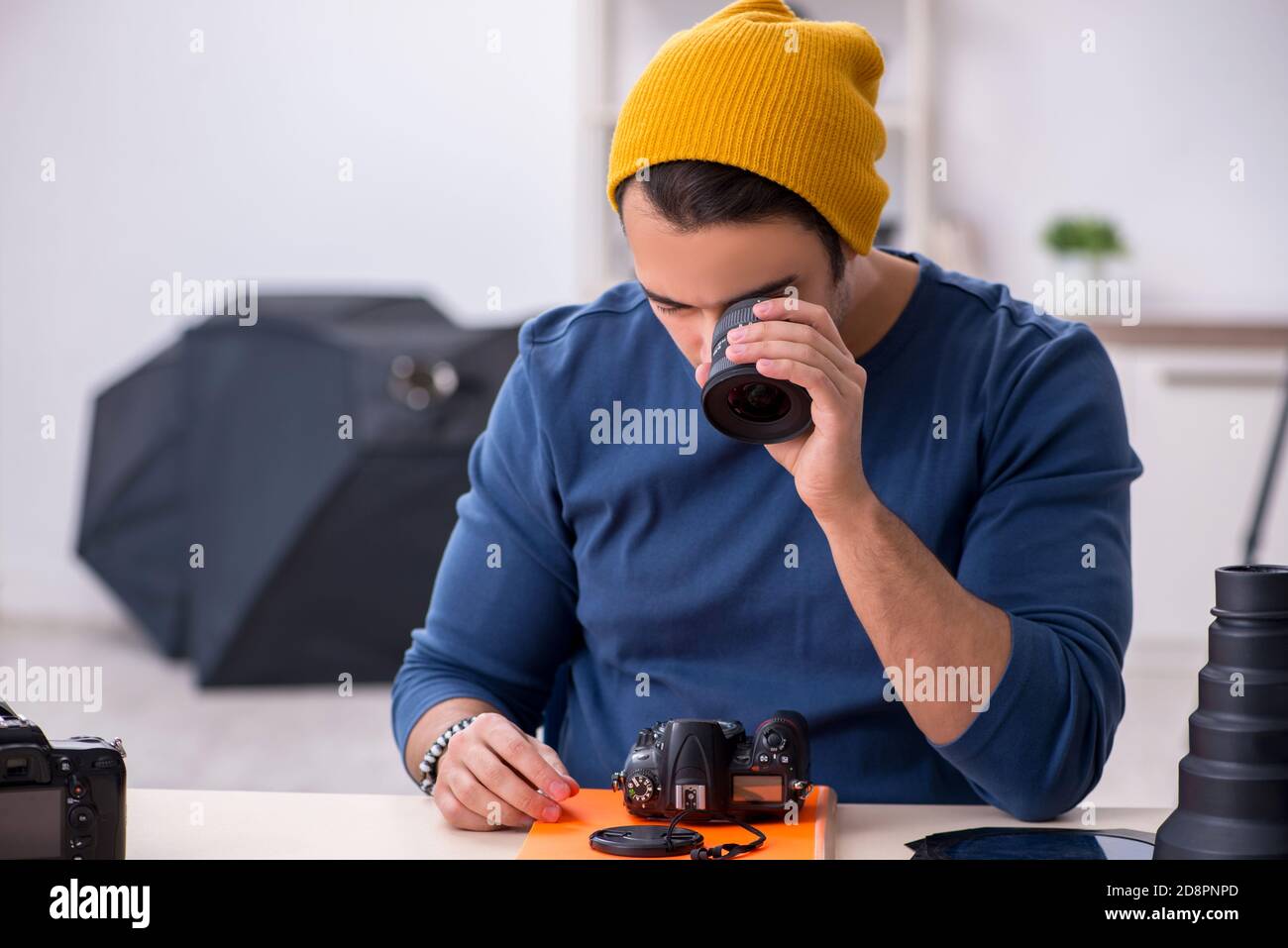 Young photographer working in the studio Stock Photo - Alamy