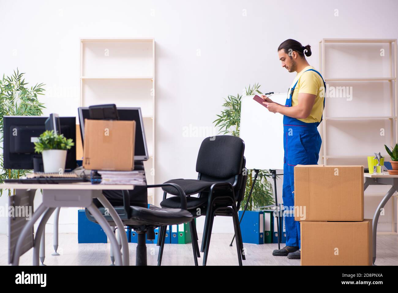 Young male contractor in the moving concept Stock Photo - Alamy