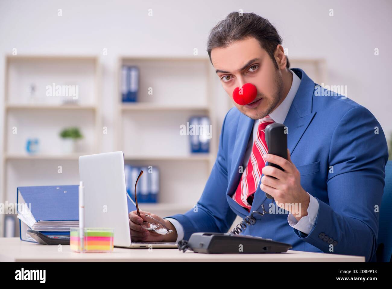Funny employee clown working in the office room Stock Photo - Alamy