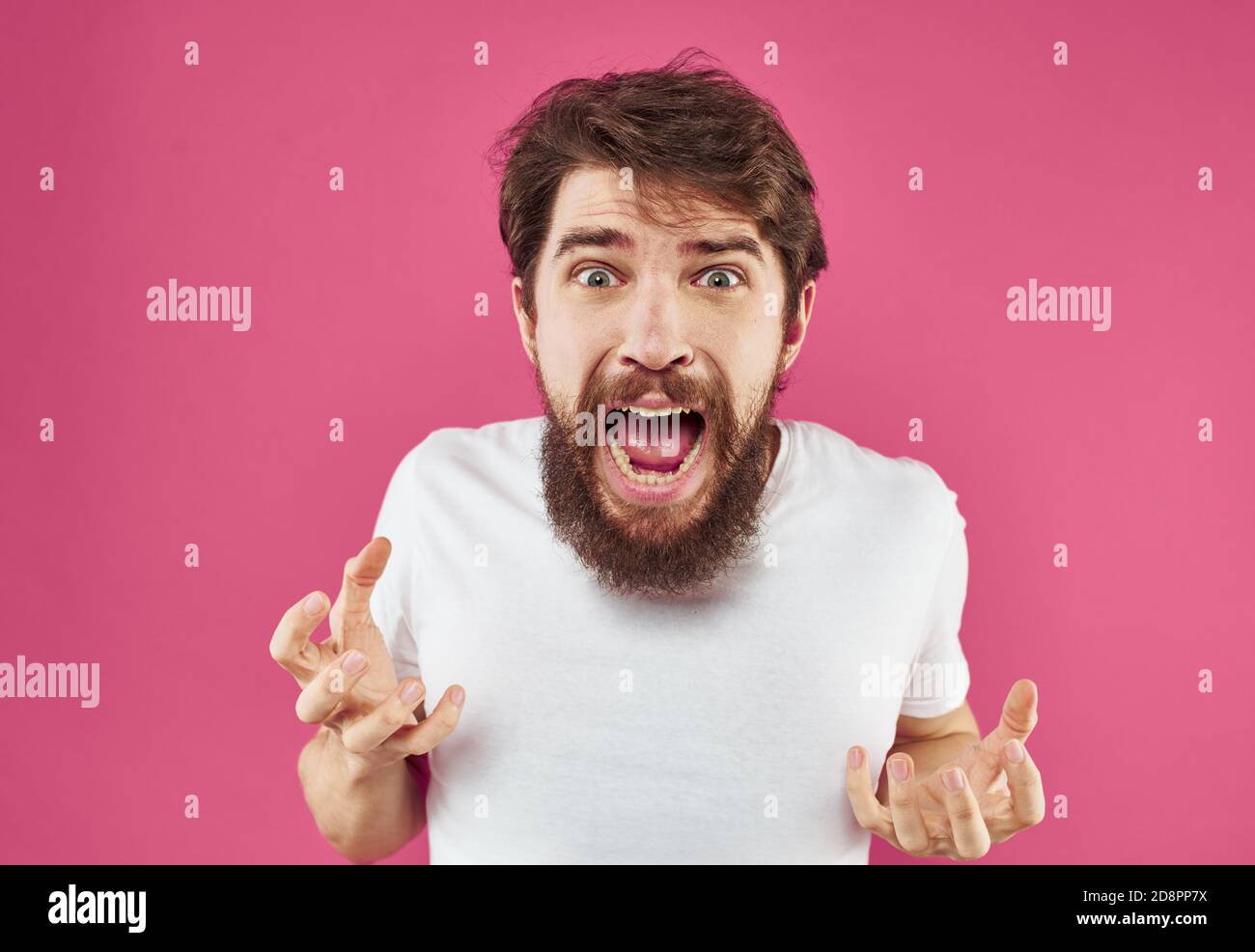 An angry man with a bushy beard bared his teeth against a pink ...