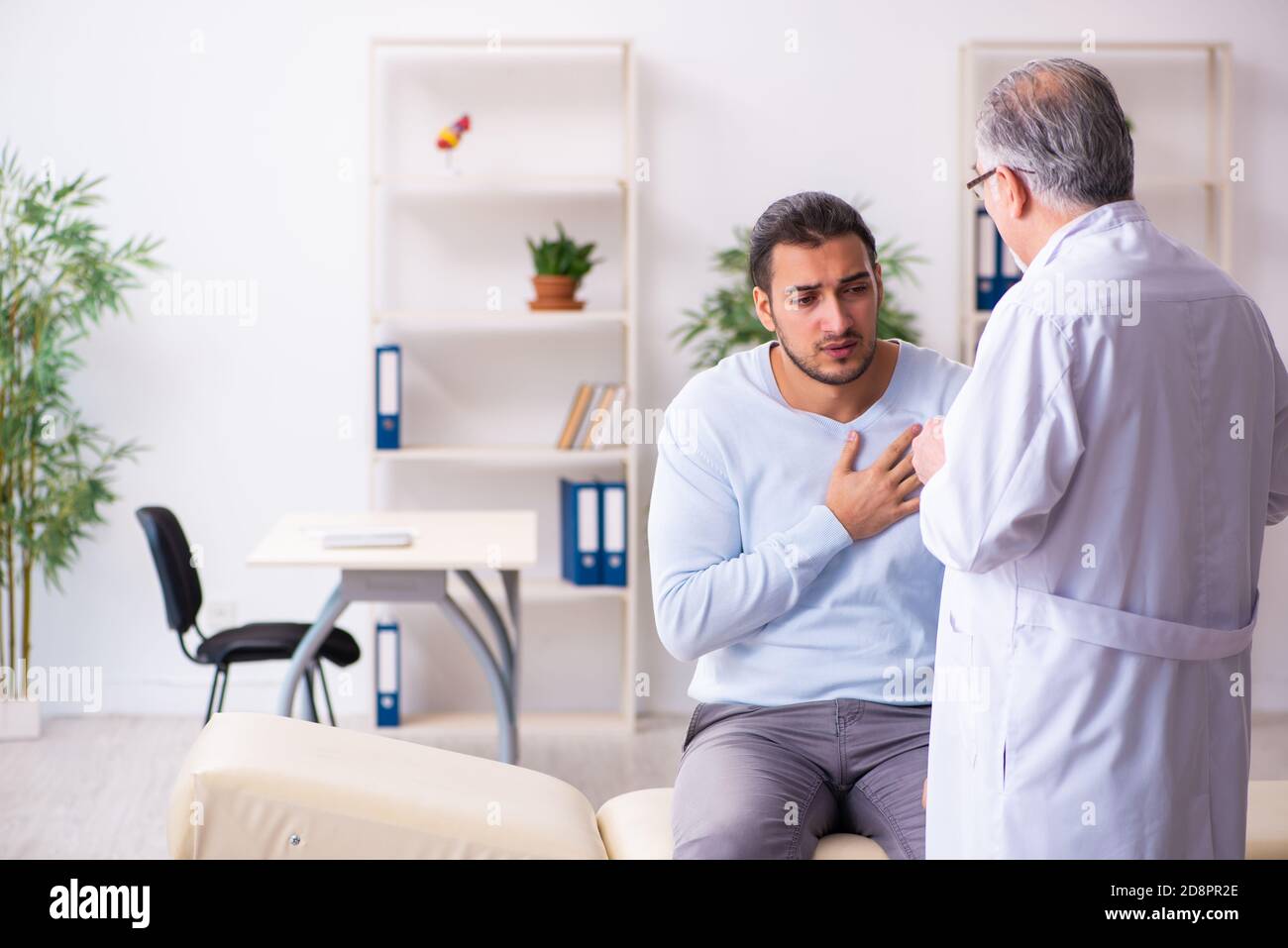 Sick man visiting old doctor Stock Photo - Alamy