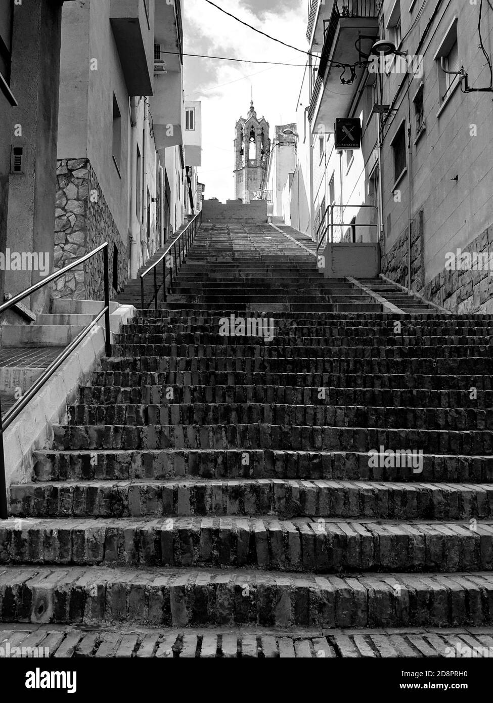 Vertical grayscale shot of staircases with buildings on both sides ...