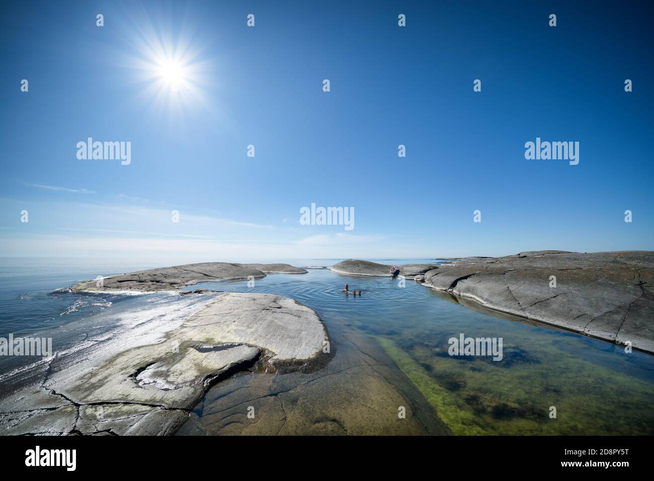 Swimming in a clear water lagoon at Smörskär island, Inkoo, Finland ...