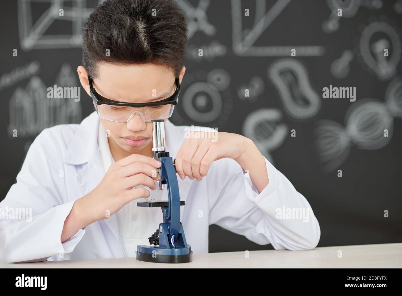 Boy looking through microscope Stock Photo - Alamy