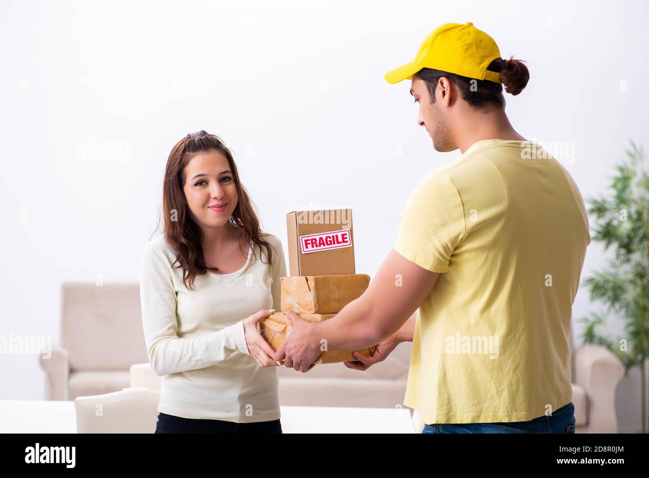 Young courier delivering parcel to the office Stock Photo - Alamy