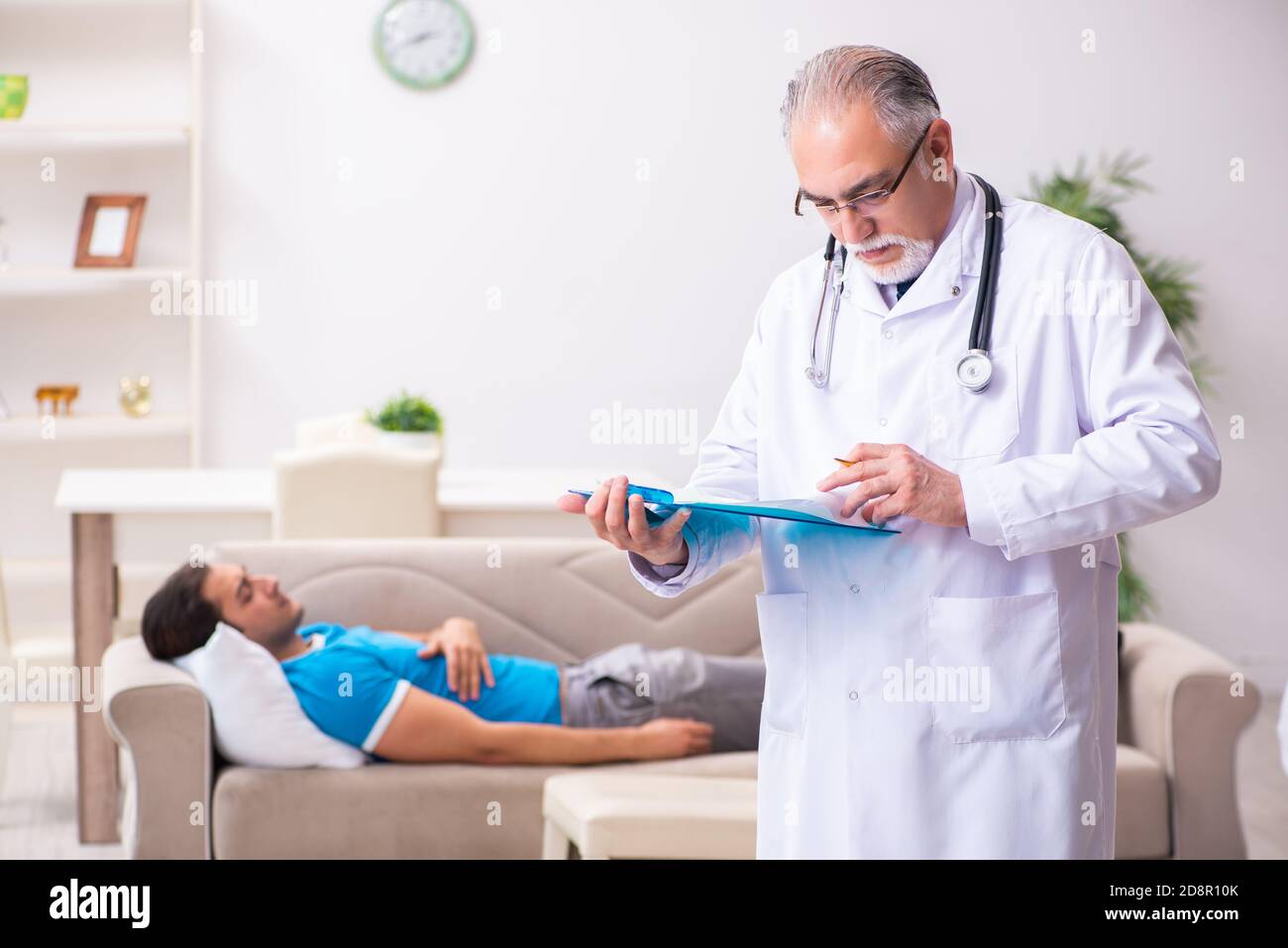 Two doctors visiting sick man at home Stock Photo - Alamy