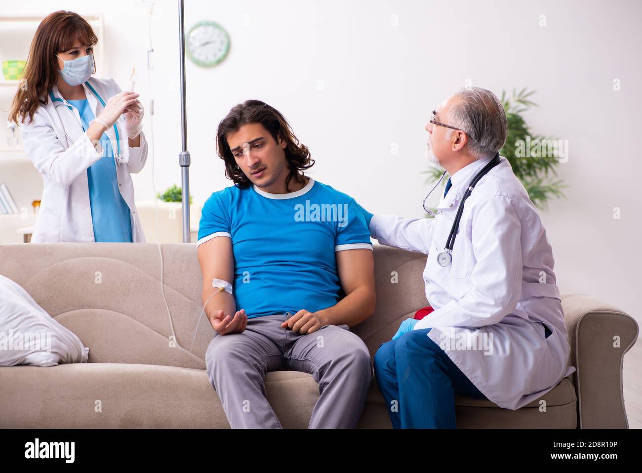Two doctors visiting sick man at home Stock Photo - Alamy