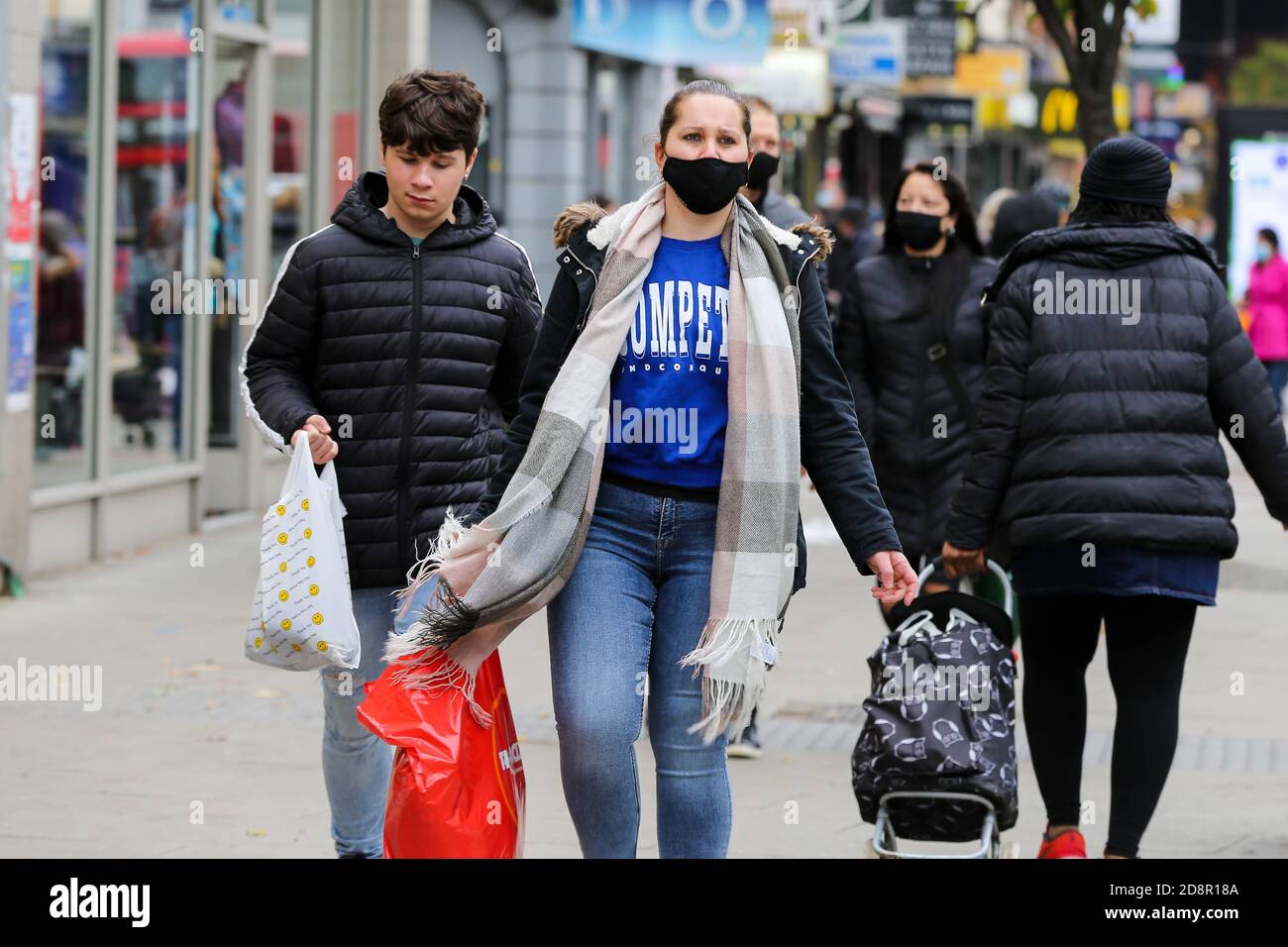 A woman wearing a face mask as a preventive measure walks on the street ...